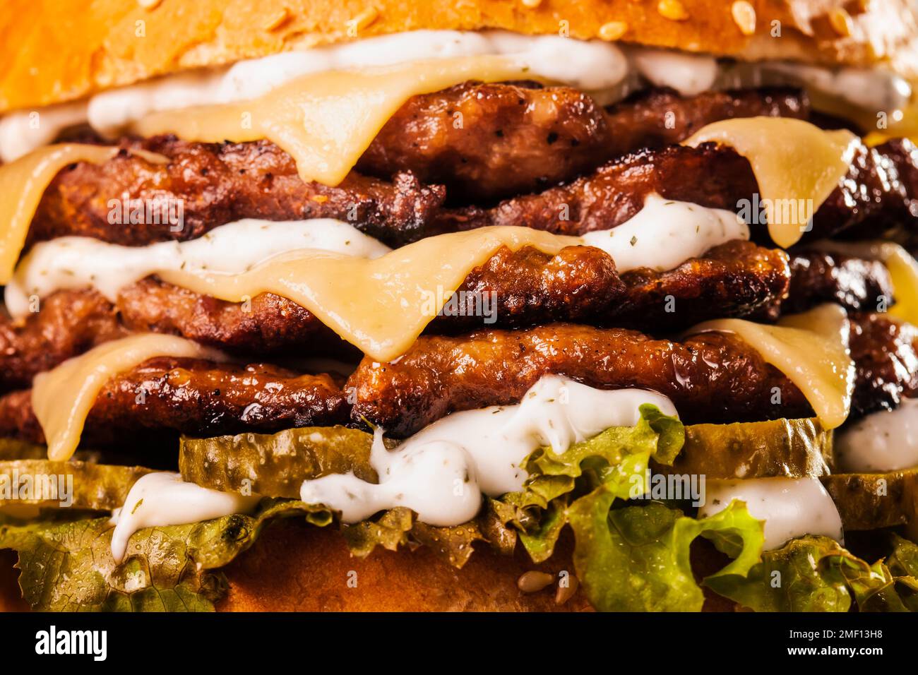 Abstract junk food. Quadruple burger with cheese cucumber and lettuce ...