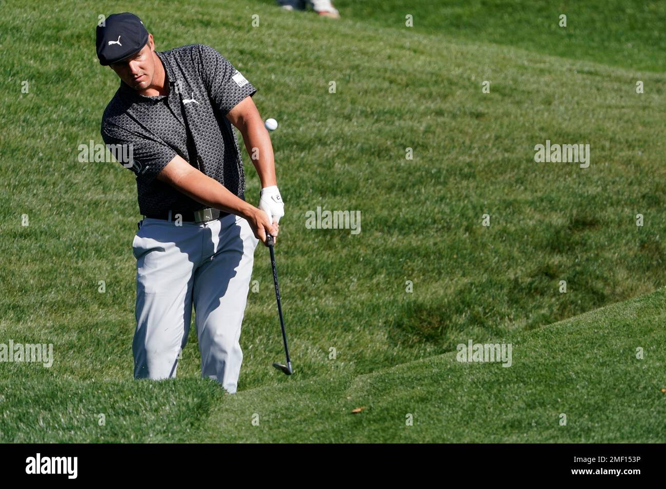 Bryson DeChambeau chips to the green on the ninth hole during the first ...