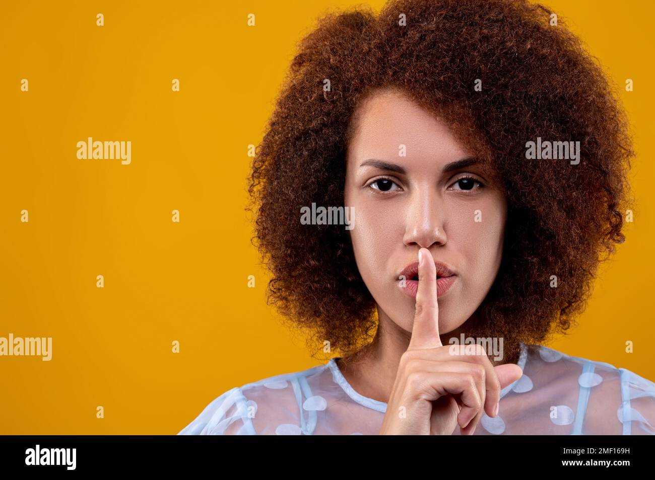 Pretty young woman showing a hush sign Stock Photo - Alamy
