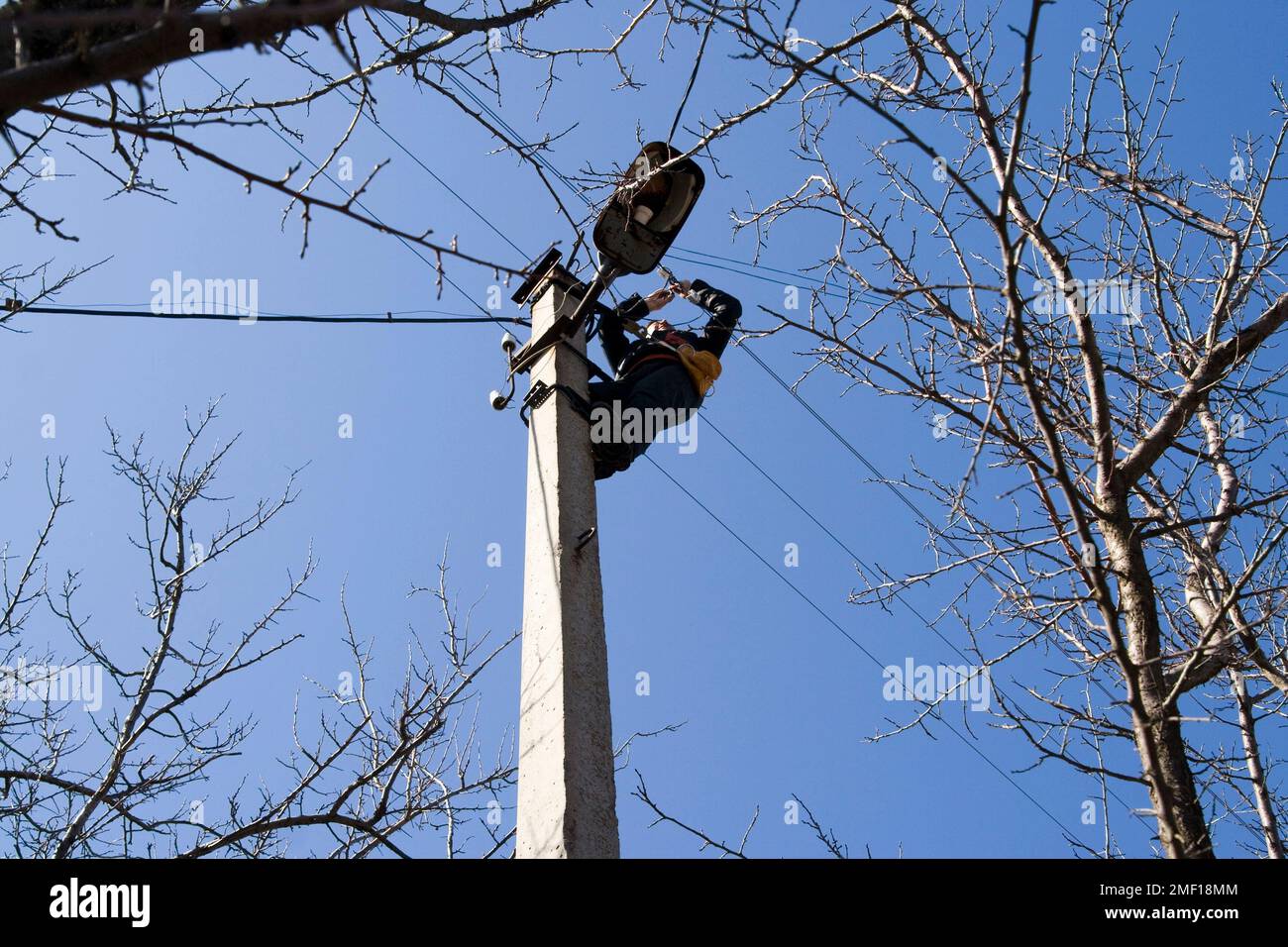 An electrician repairs power lines on a pole Stock Photo - Alamy