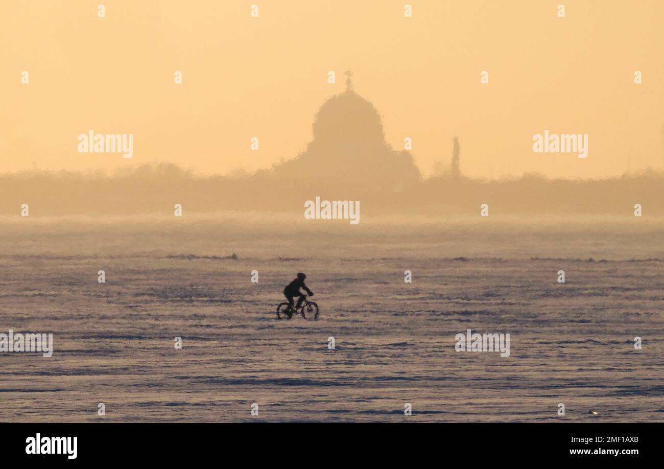 A man rides a bike in the frozen Finnish Gulf outside St. Petersburg ...