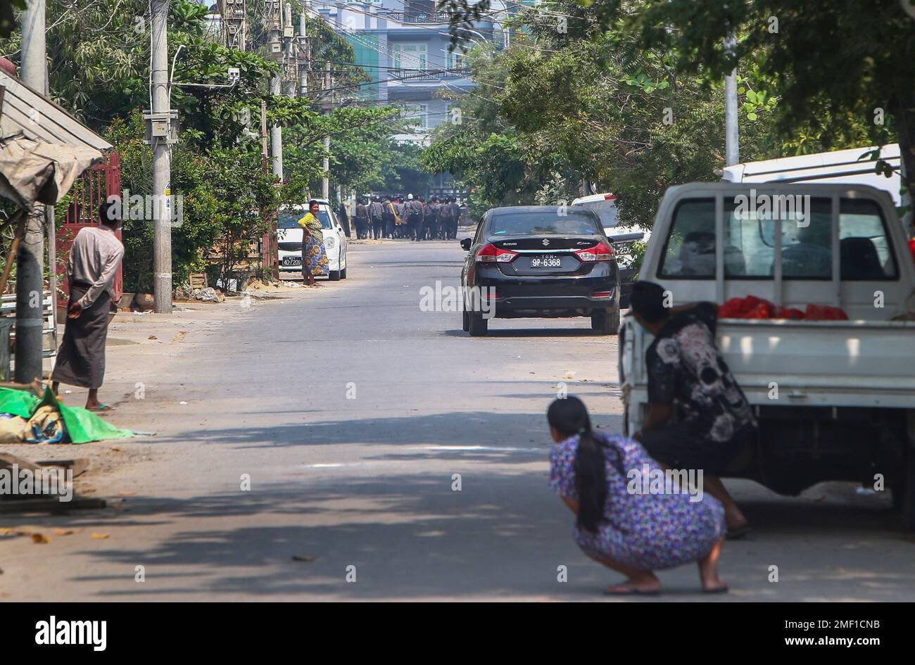 People taking cover behind vehicles watch as soldiers and riot ...