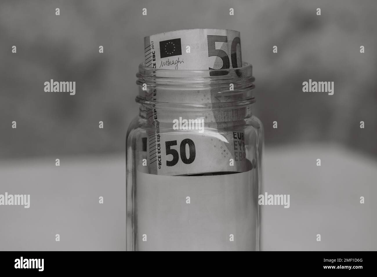 Composition with saving money banknotes (50 EURO) in a glass jar with ...