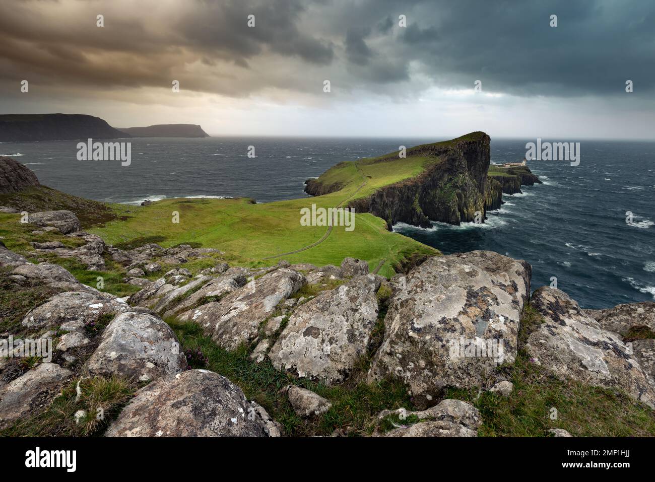 Storm clouds above dramatic view of Neist Point lighthouse on The Isle ...
