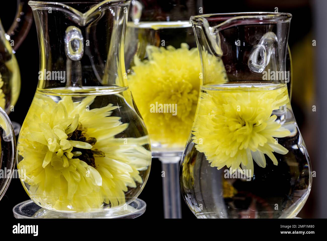The glass jars full of water with yellow flowers inside Stock Photo - Alamy