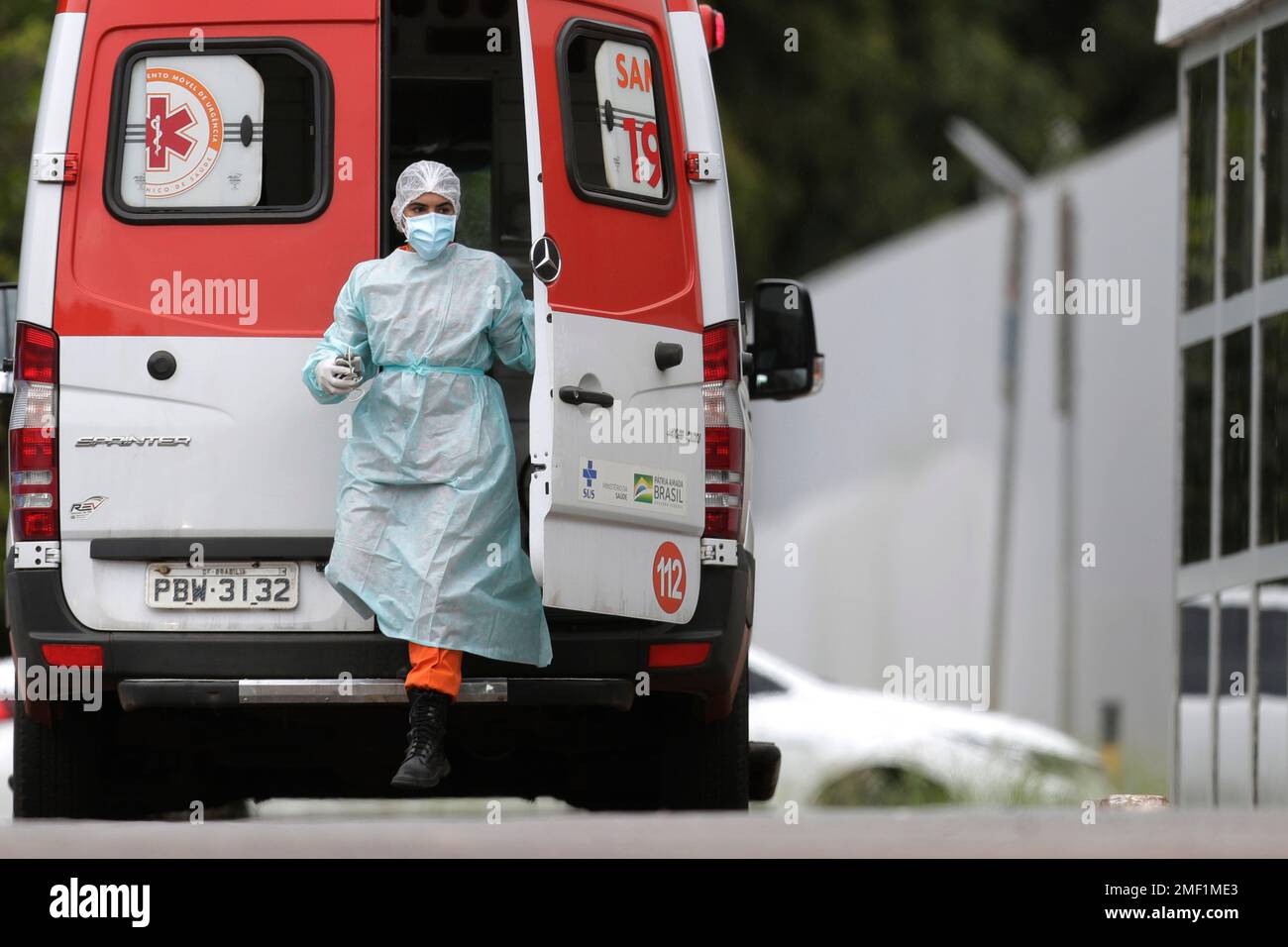 A healthcare worker arrives in an ambulance bringing a patient ...