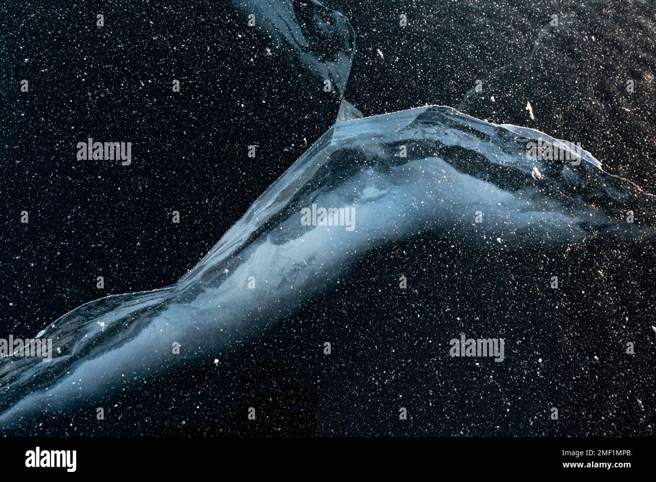 Natural blue ice on the lake. Beautiful winter landscape. Cracks in the ...