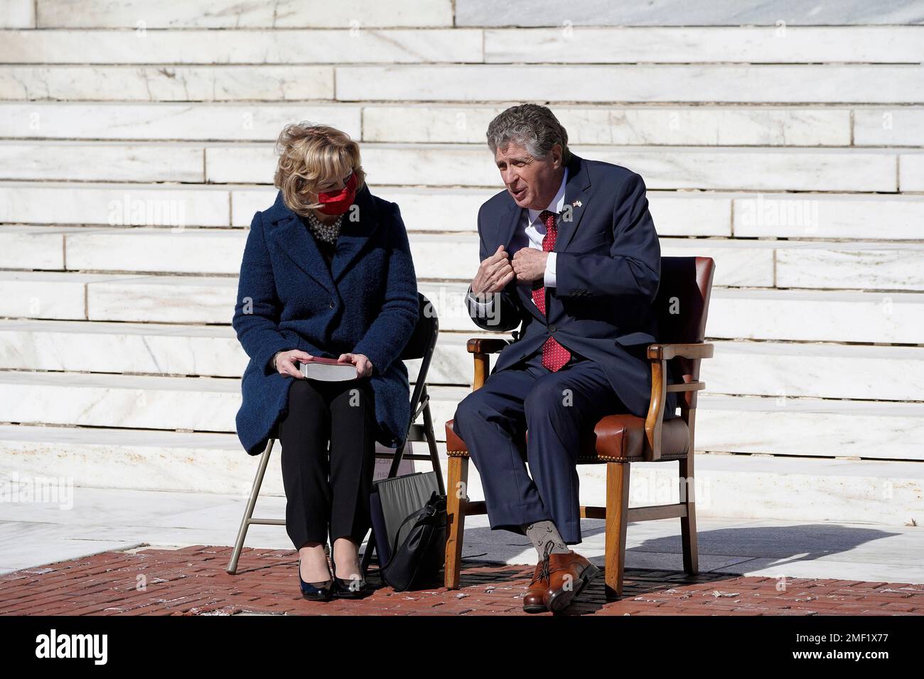 Rhode Island Democratic Gov. Dan McKee, right, prepares to put on a ...