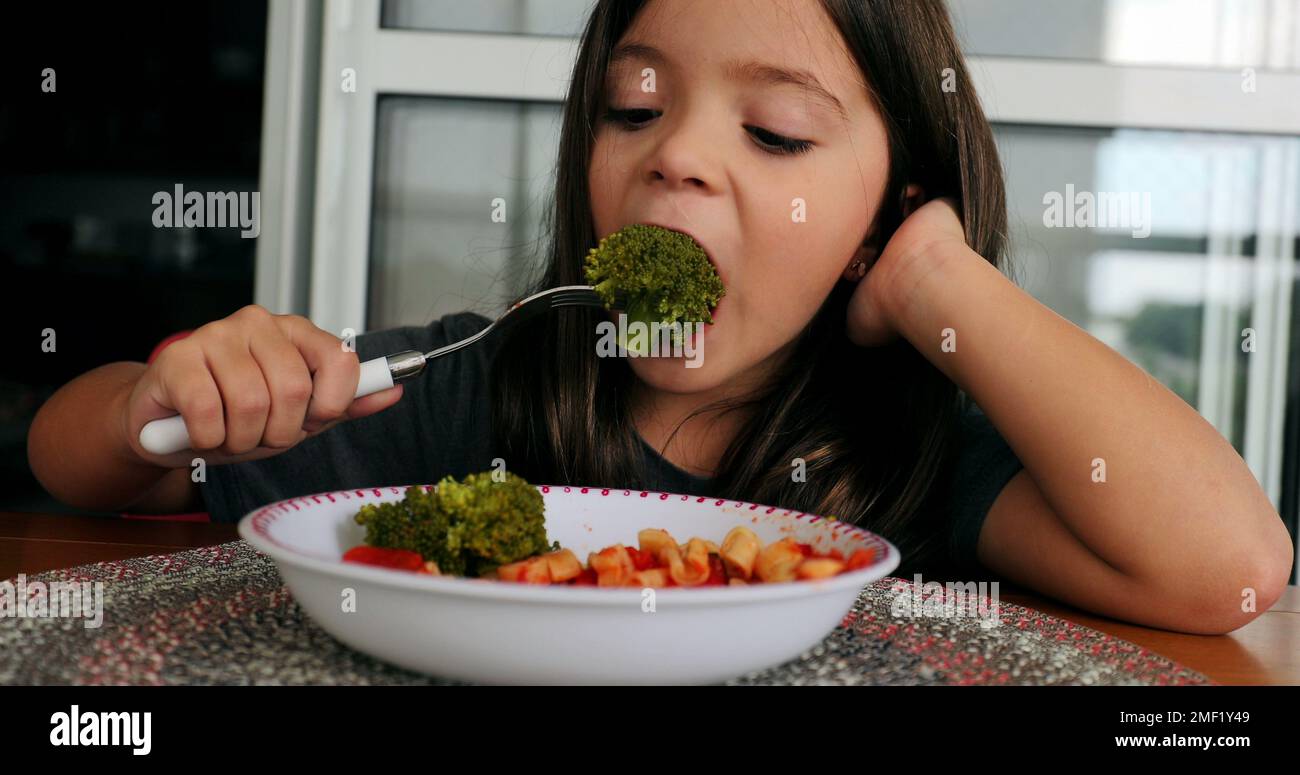 Kid eating broccoli small girl eats healthy vegetable for lunch Stock ...