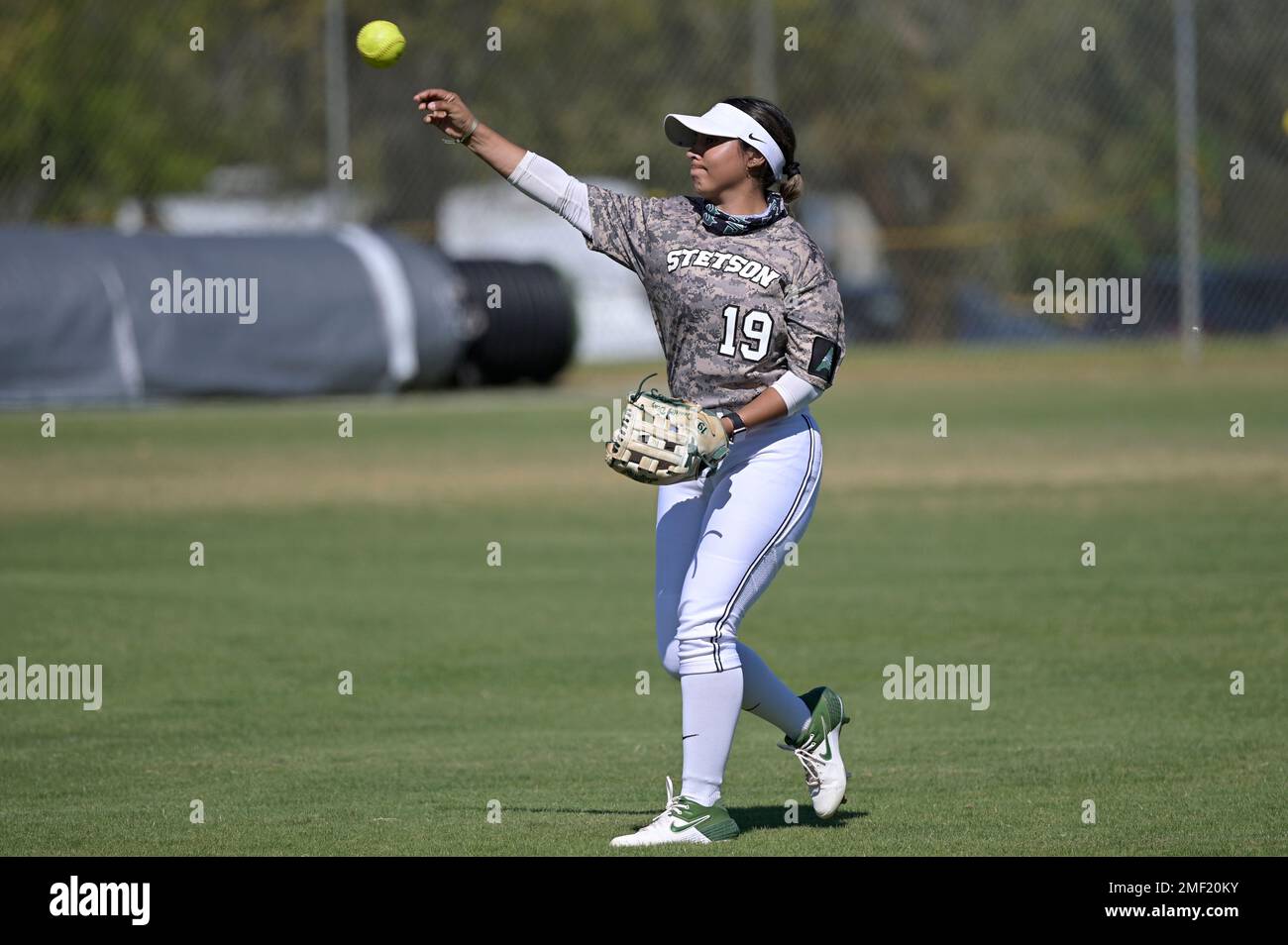 Stetson outfielder Danielle Diaz (19) throws before an NCAA softball ...