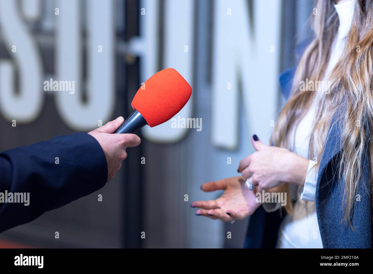 TV journalist making media interview with unrecognizable female person ...