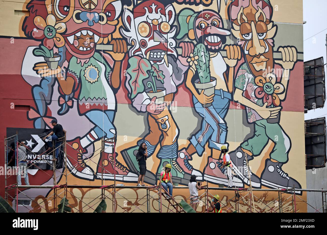 Workers make finishing touches on a large clean air-themed mural ...