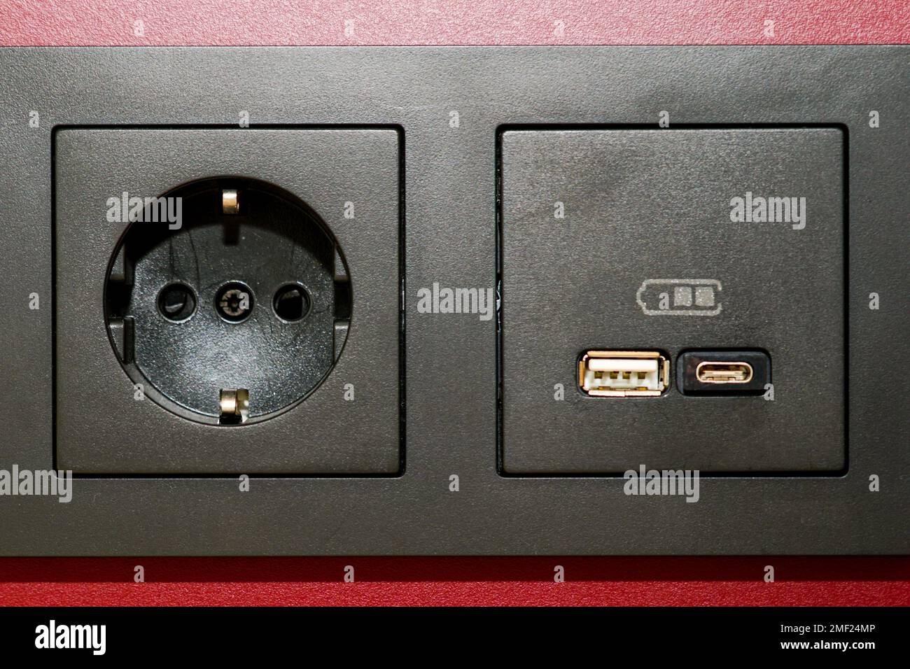 A modern black 220V, USB and USB C socket block is built into the wall ...