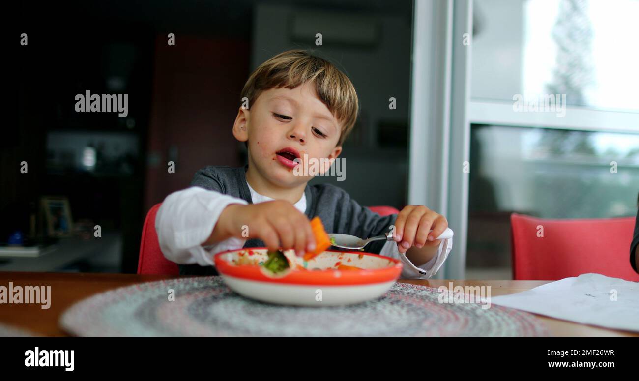 One happy little boy eating food by himself healthy lunch Stock Photo ...