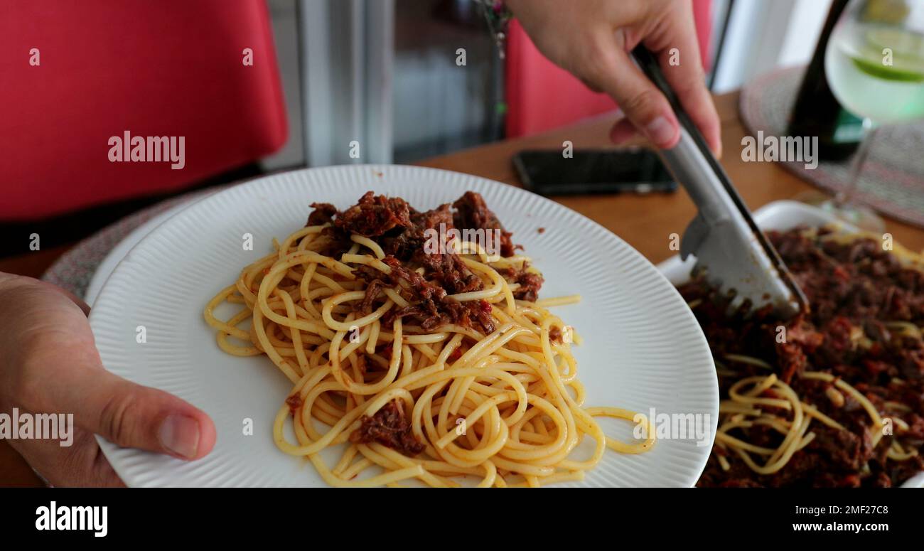 Pasta on plate hand serving spaghetti carb lunch meal Stock Photo - Alamy