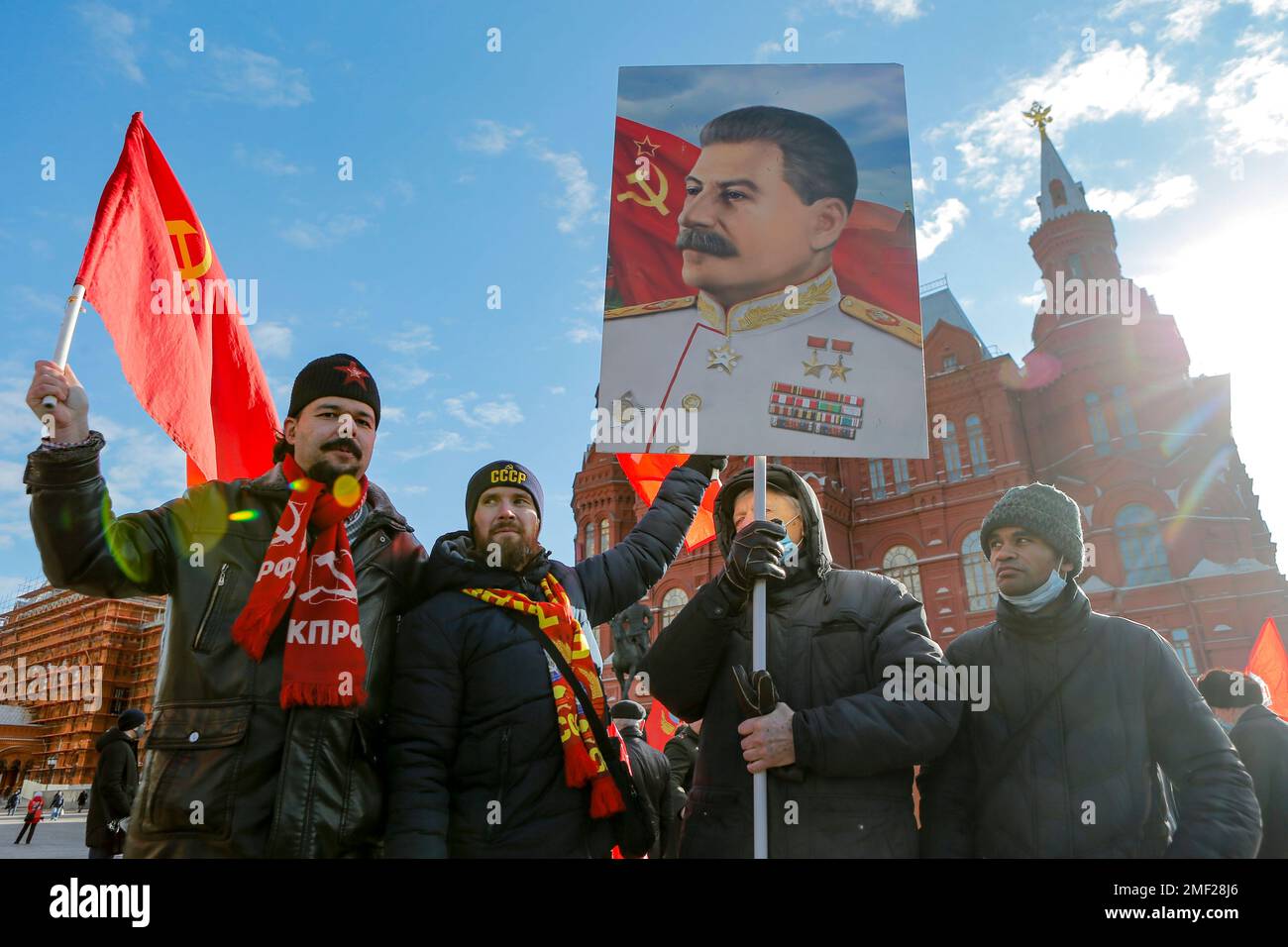 Communist party supporters pose with red flags and a portrait of Josef ...