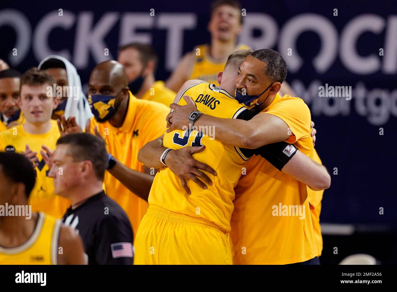Michigan forward Austin Davis (51) is hugged by coach Juwan Howard ...