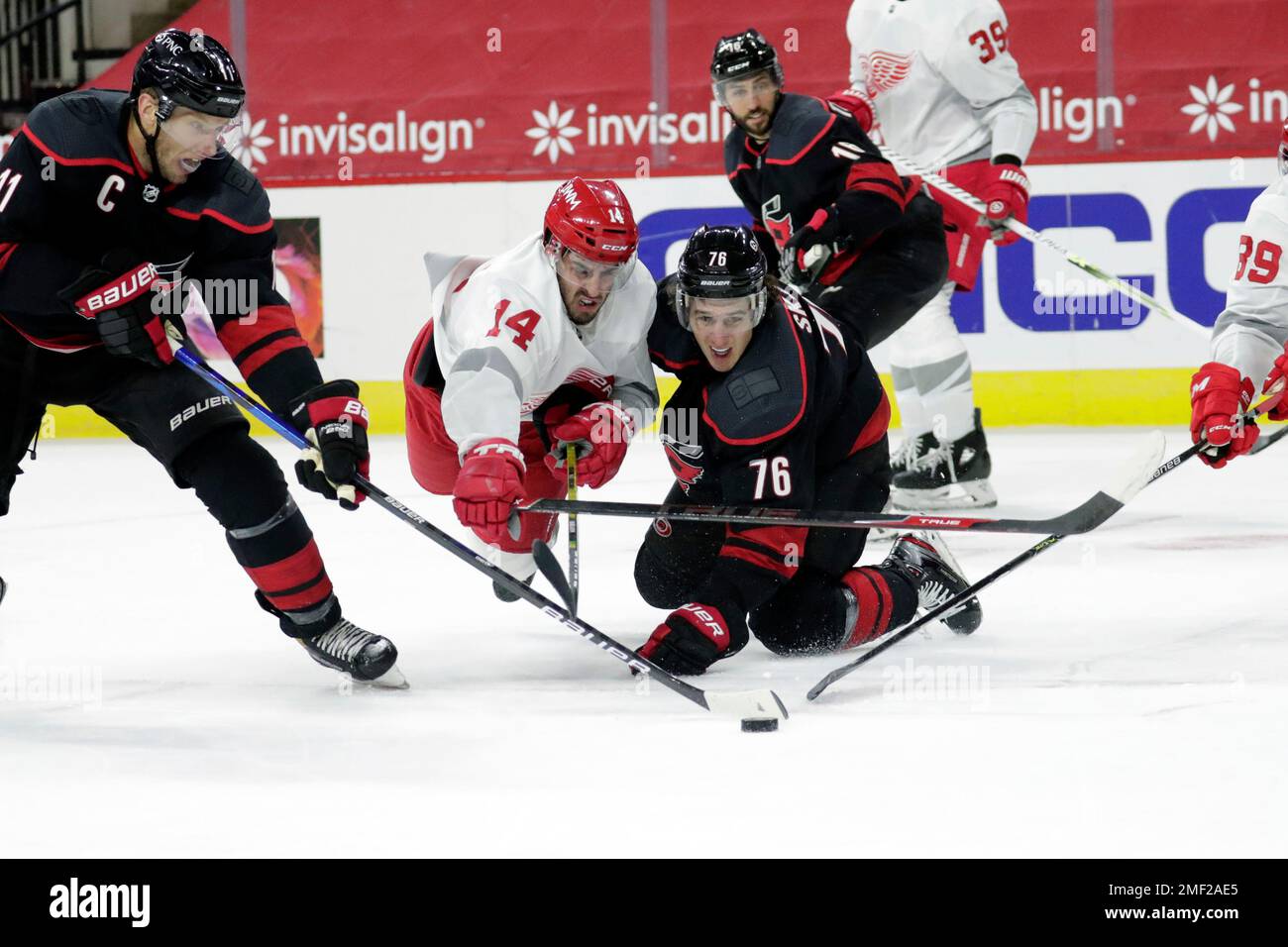 Carolina Hurricanes' Jordan Staal (11) and Brady Skjei (76) battle Detroit Red Wings' Robby ...