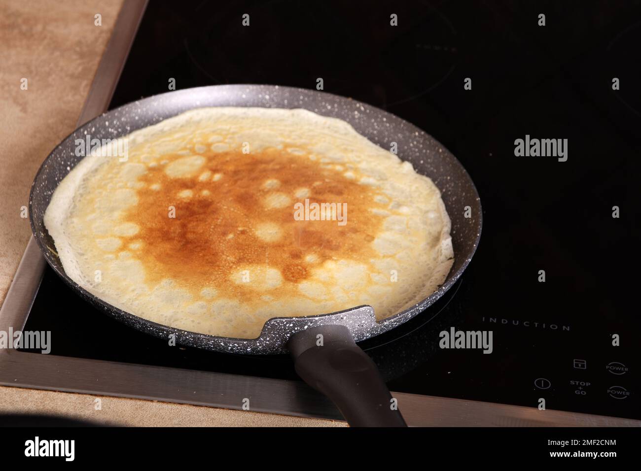 photo thin pancake cooked in a pan on the stove Stock Photo - Alamy