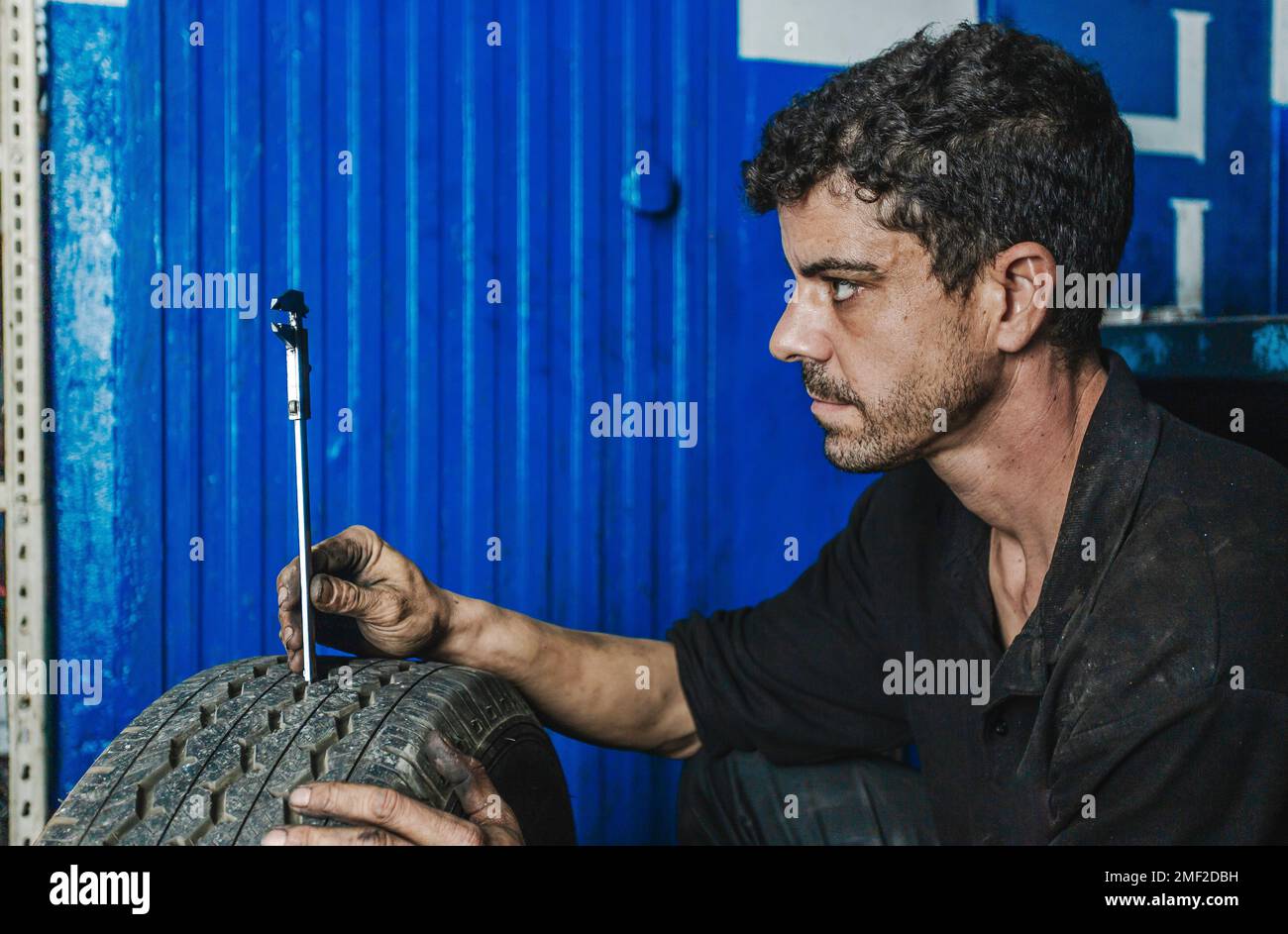 Side view focused male mechanic using caliper while checking and ...