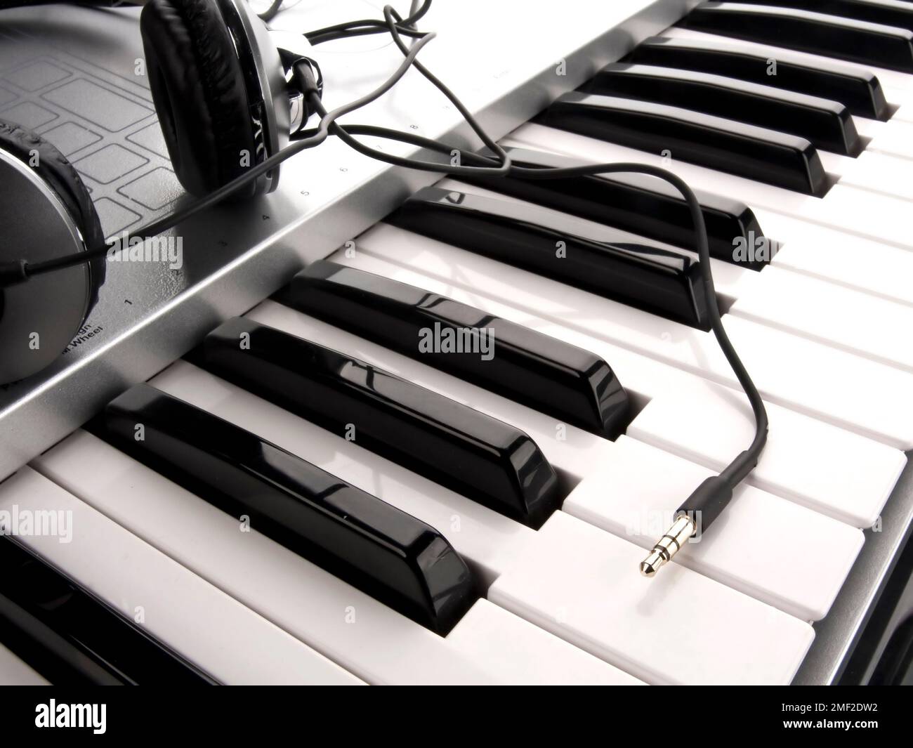 A grayscale of the electric piano keyboard with a plug and headphones ...