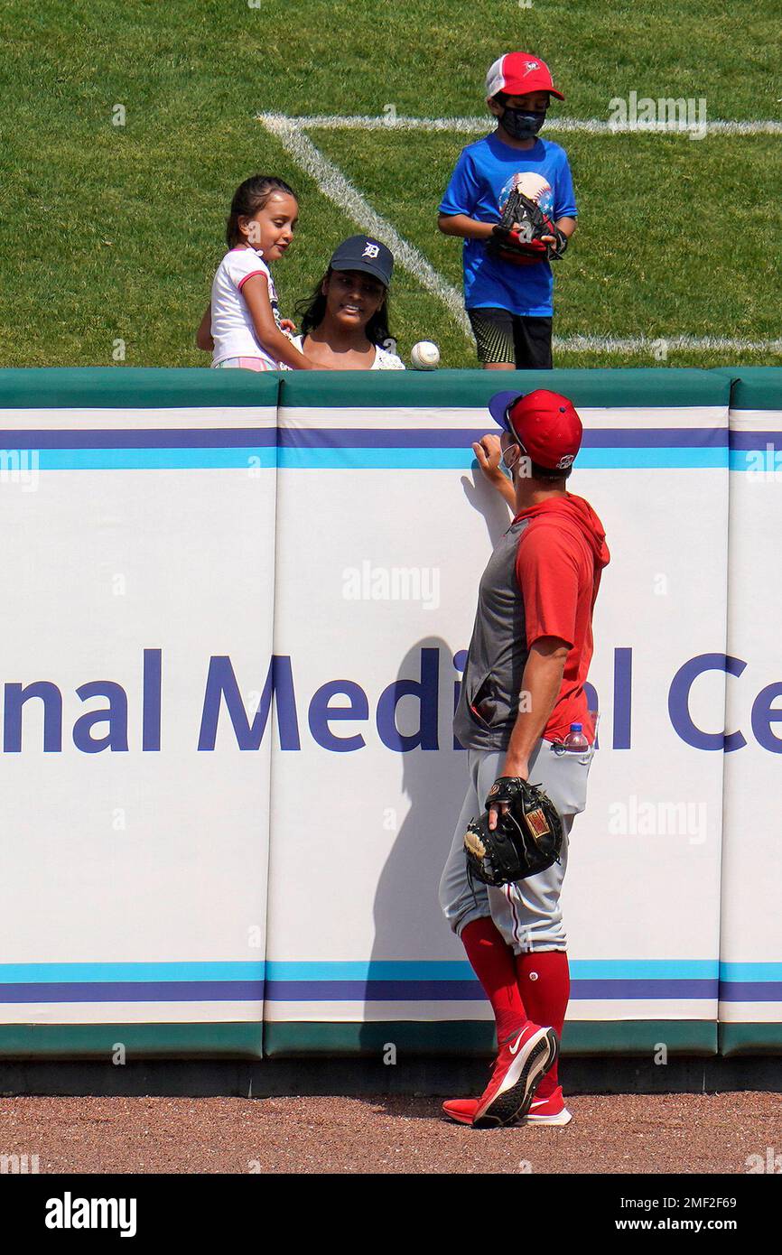 A young fan gets a ball during batting practice before a spring ...