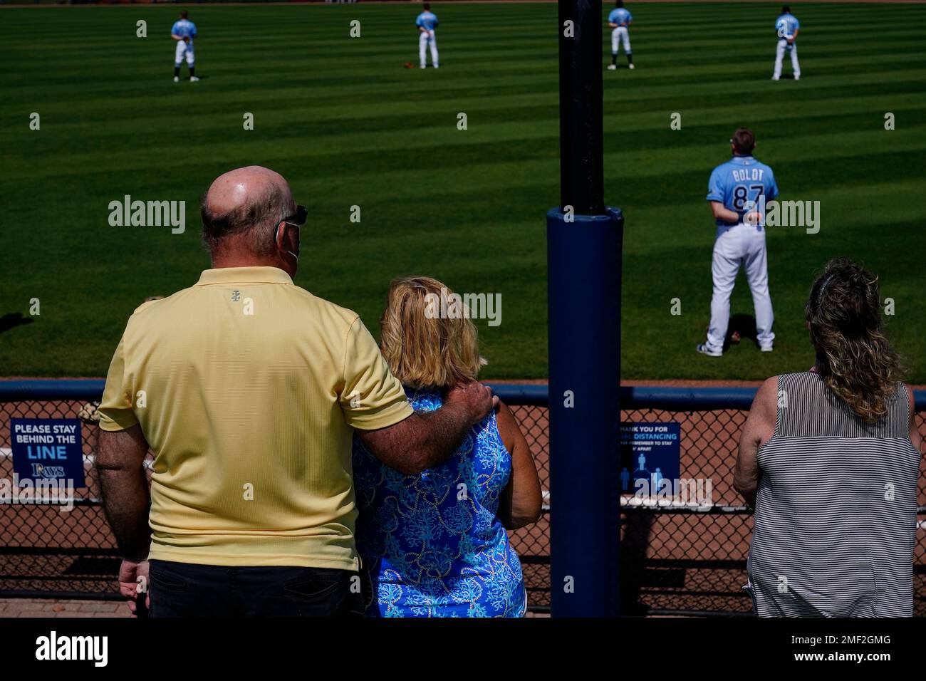 Baseball fans stand during the National Anthem before a spring training ...