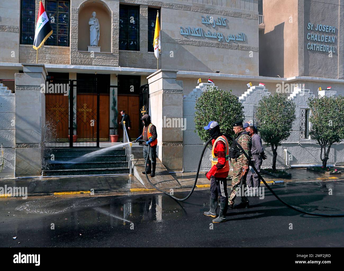 Municipal workers clean the area around St. Joseph Chaldean Church ...