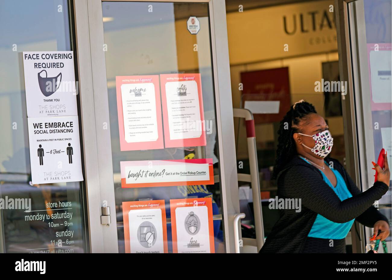 A customer exits a store with a mask required sign displayed, Tuesday ...