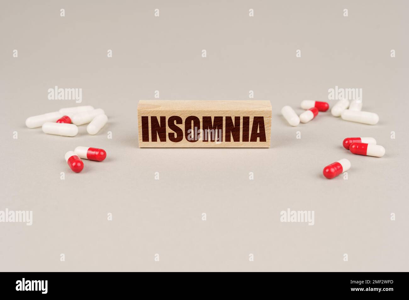 Medical concept. On a gray surface are tablets, capsules and a wooden ...