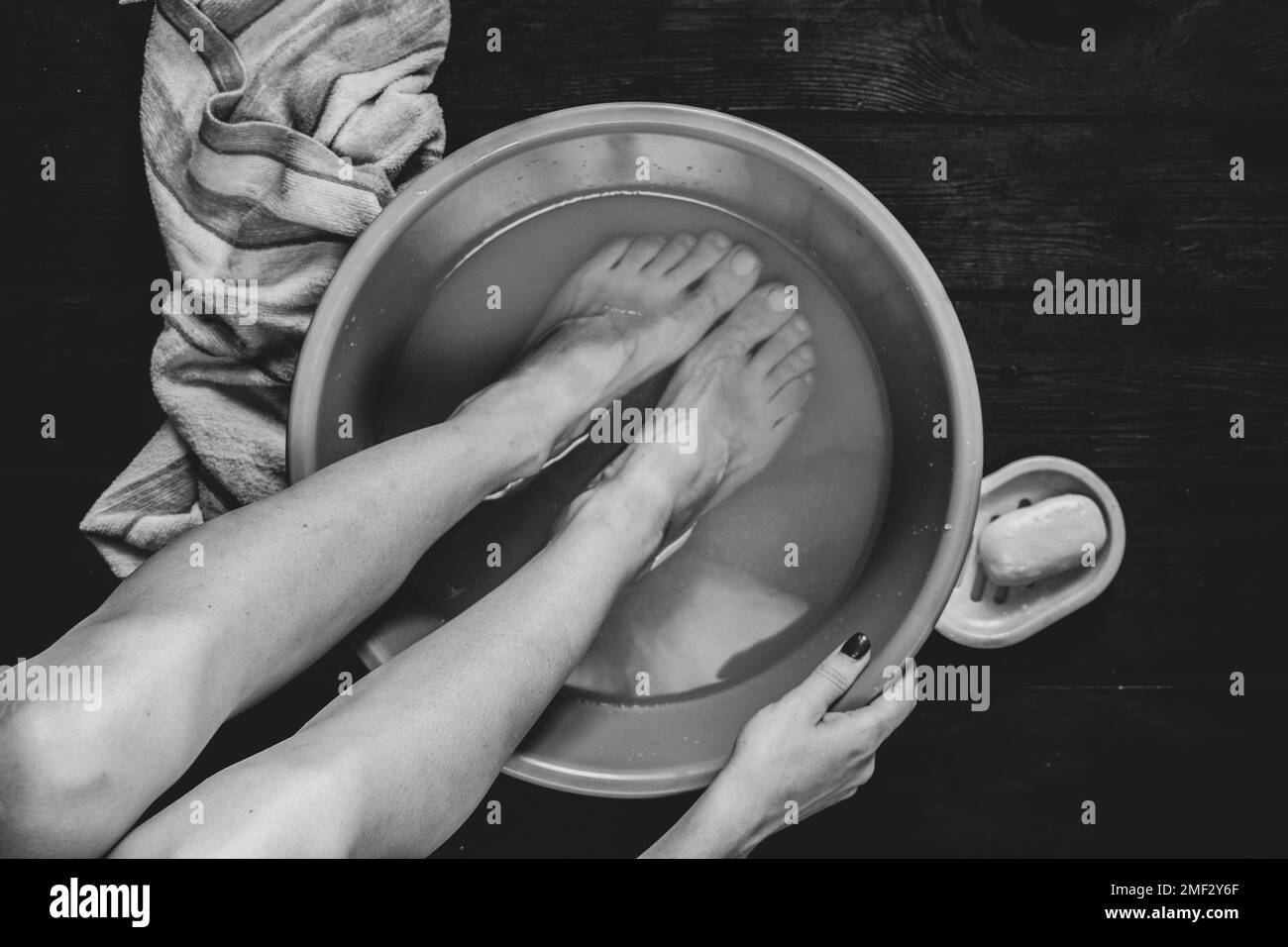 Girl Washes Her Feet In A Bowl Of Water On The Wooden Floor At Home Foot Care Wash Feet At