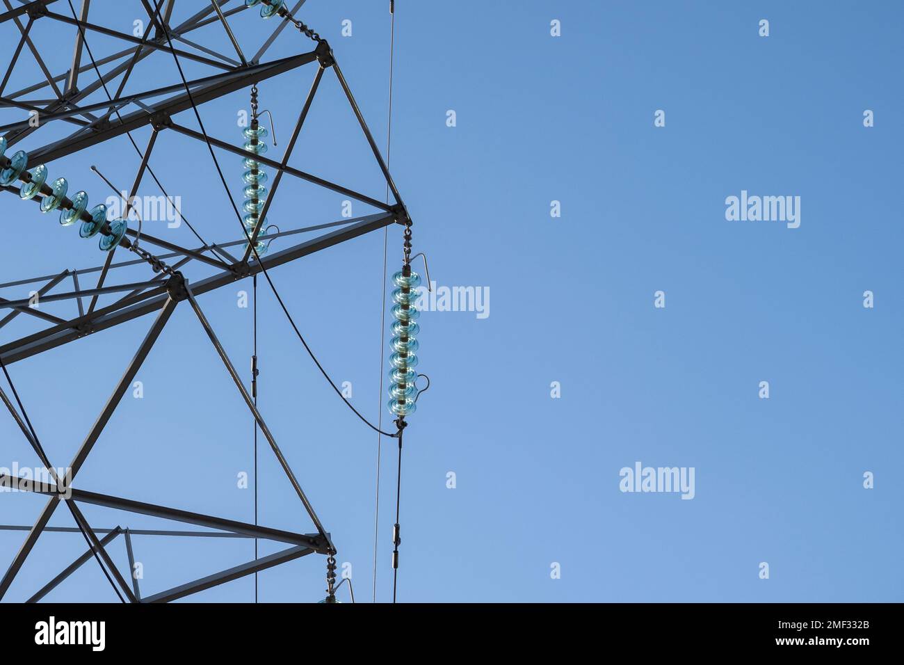 Electircity pylons against a clear blue sky on a cold winters day in ...