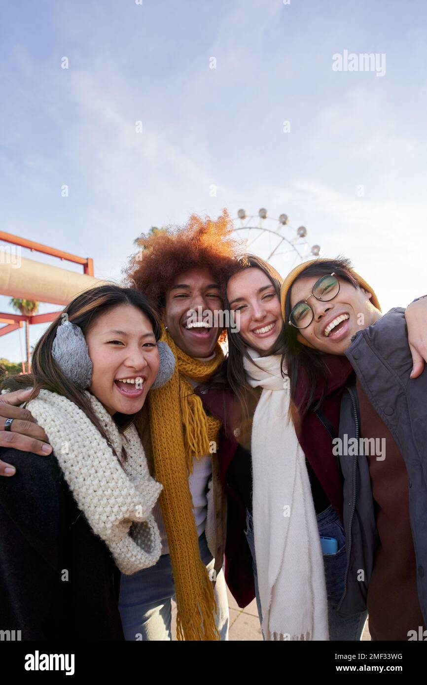 Vertical photo of Four Happy friends taking smiling selfie looking ...