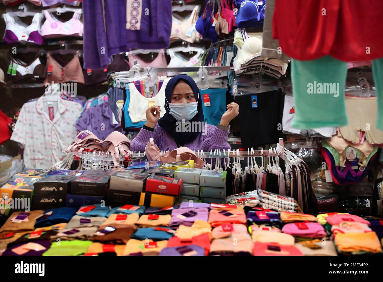 A clothing vendor wearing face masks as a precaution against ...