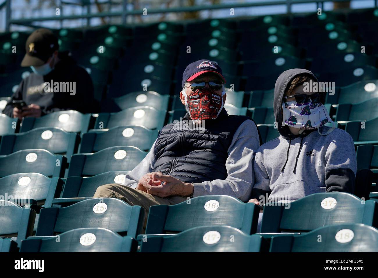 Masked up baseball fans wait for a spring training baseball game ...