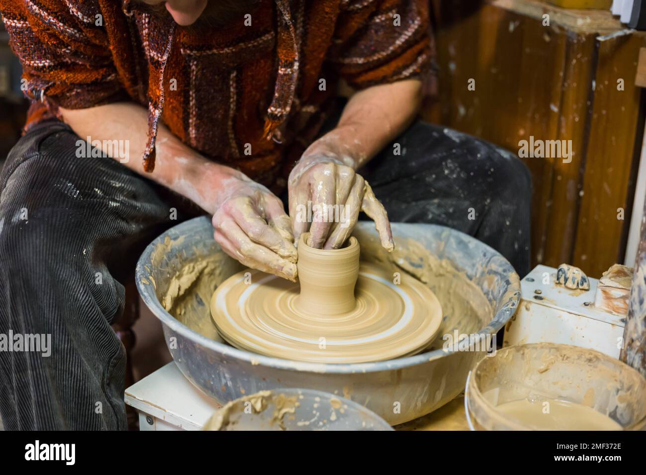 Professional male potter making ceramics in workshop: close up view ...
