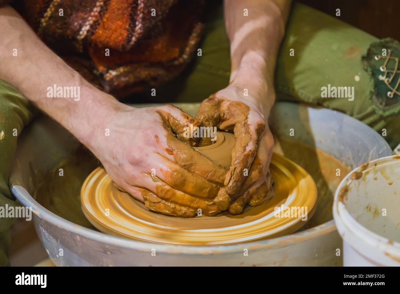Close up view - professional male potter working with clay on pottery ...