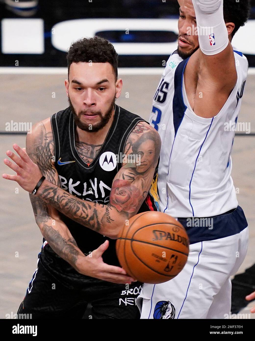 Brooklyn Nets guard Chris Chiozza, left, passes around Dallas Mavericks ...