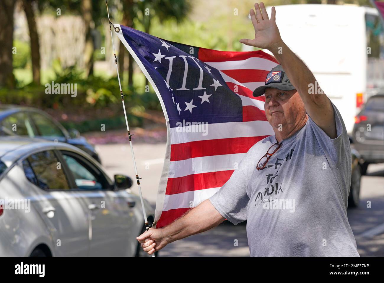 Larry Heinz waves to motorists driving by outside the convention center ...