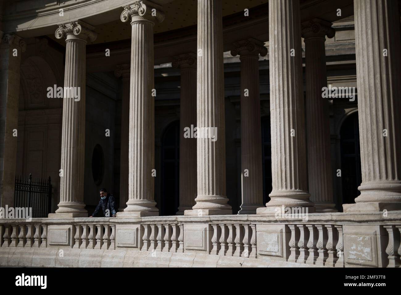 A man wearing a face mask to prevent the spread of the coronavius looks ...