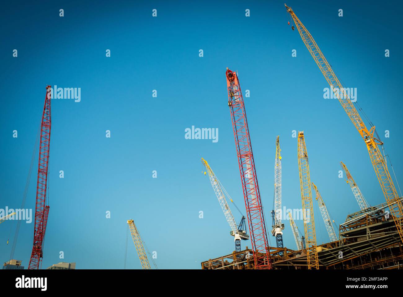 Multiple construction crane towering in the sky Stock Photo - Alamy