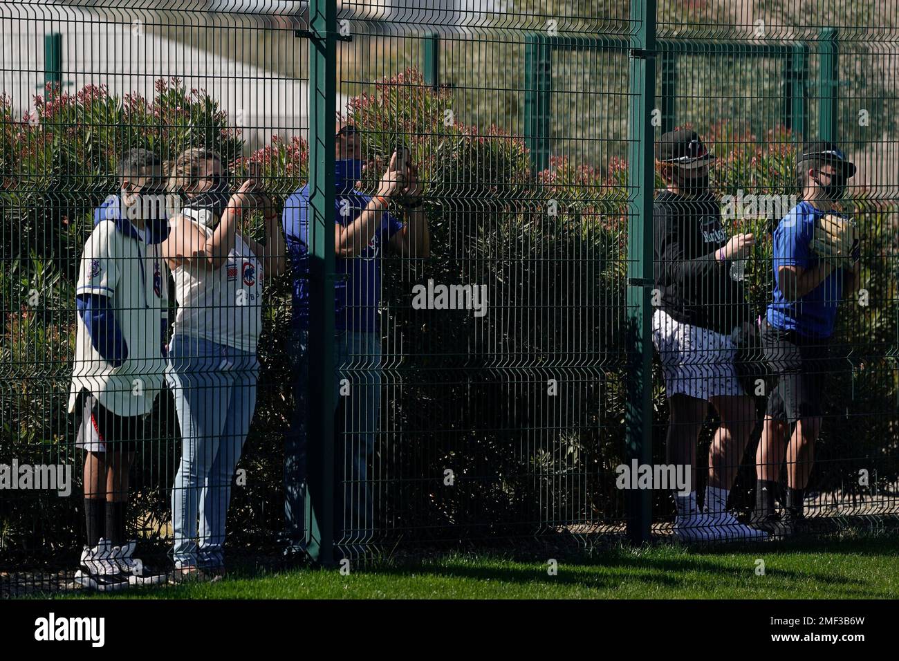 Fans watch through a fence as Chicago Cubs players train during the ...