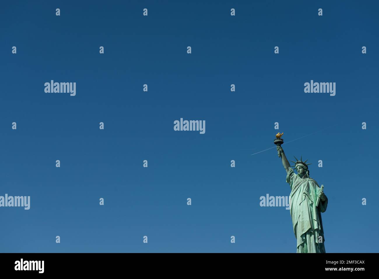 Statue of Liberty and blue skies and airplane jetstream Stock Photo - Alamy