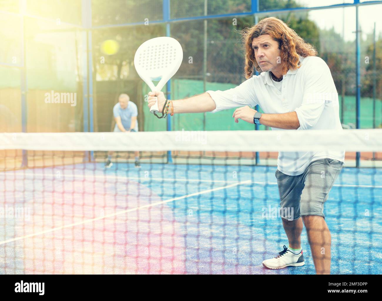 Focused adult man playing paddle tennis outdoors Stock Photo - Alamy