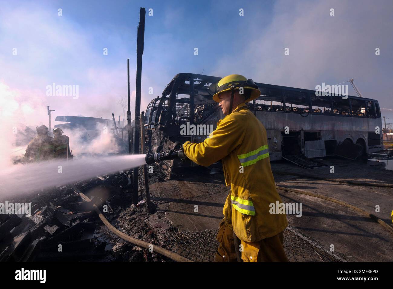 A firefighter battles a fire at a commercial yard in Compton, Calif ...