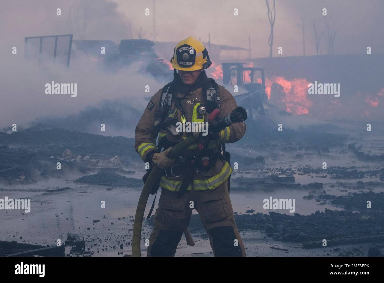 A firefighter battles a fire at a commercial yard in Compton, Calif ...