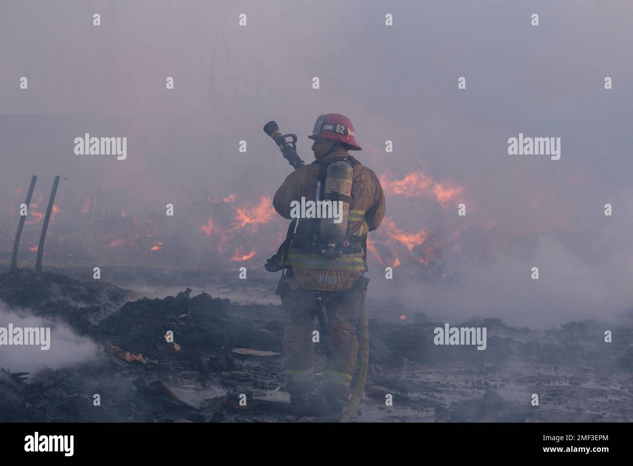 A firefighter battles a fire at a commercial yard in Compton, Calif ...