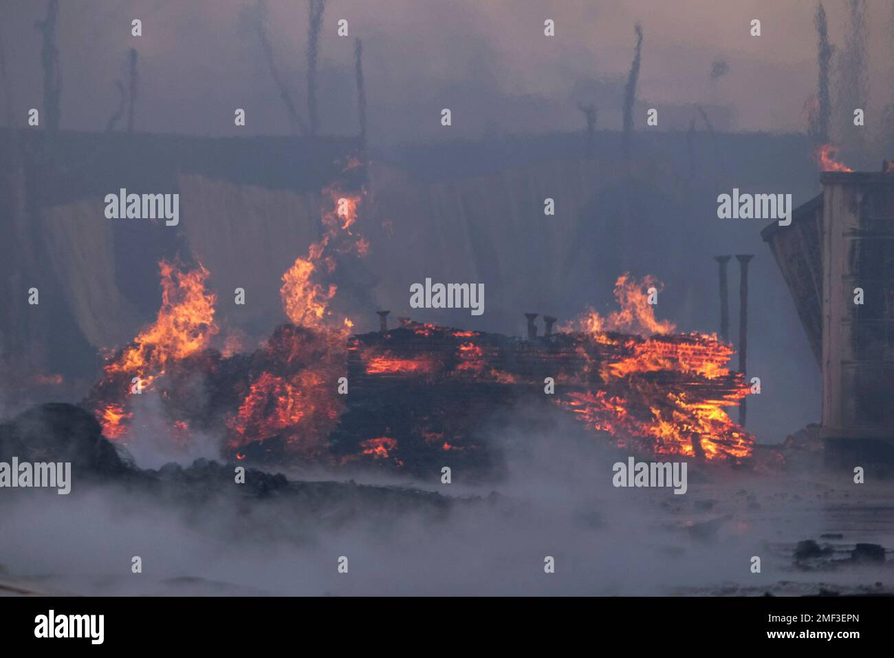 A fire burns at a commercial yard in Compton, Calif., on Friday, Feb ...