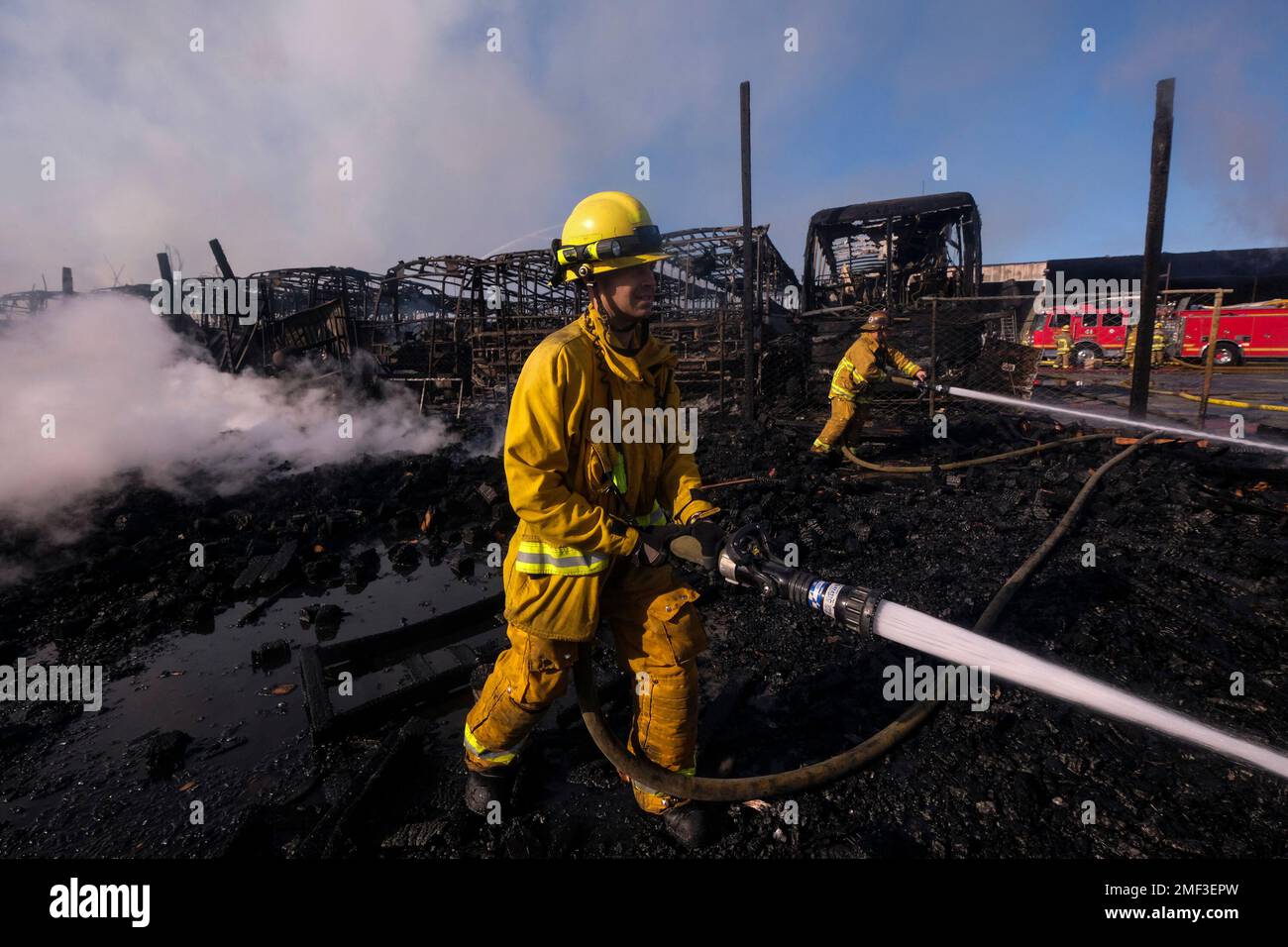 Firefighters battle a fire at a commercial yard in Compton, Calif., on ...