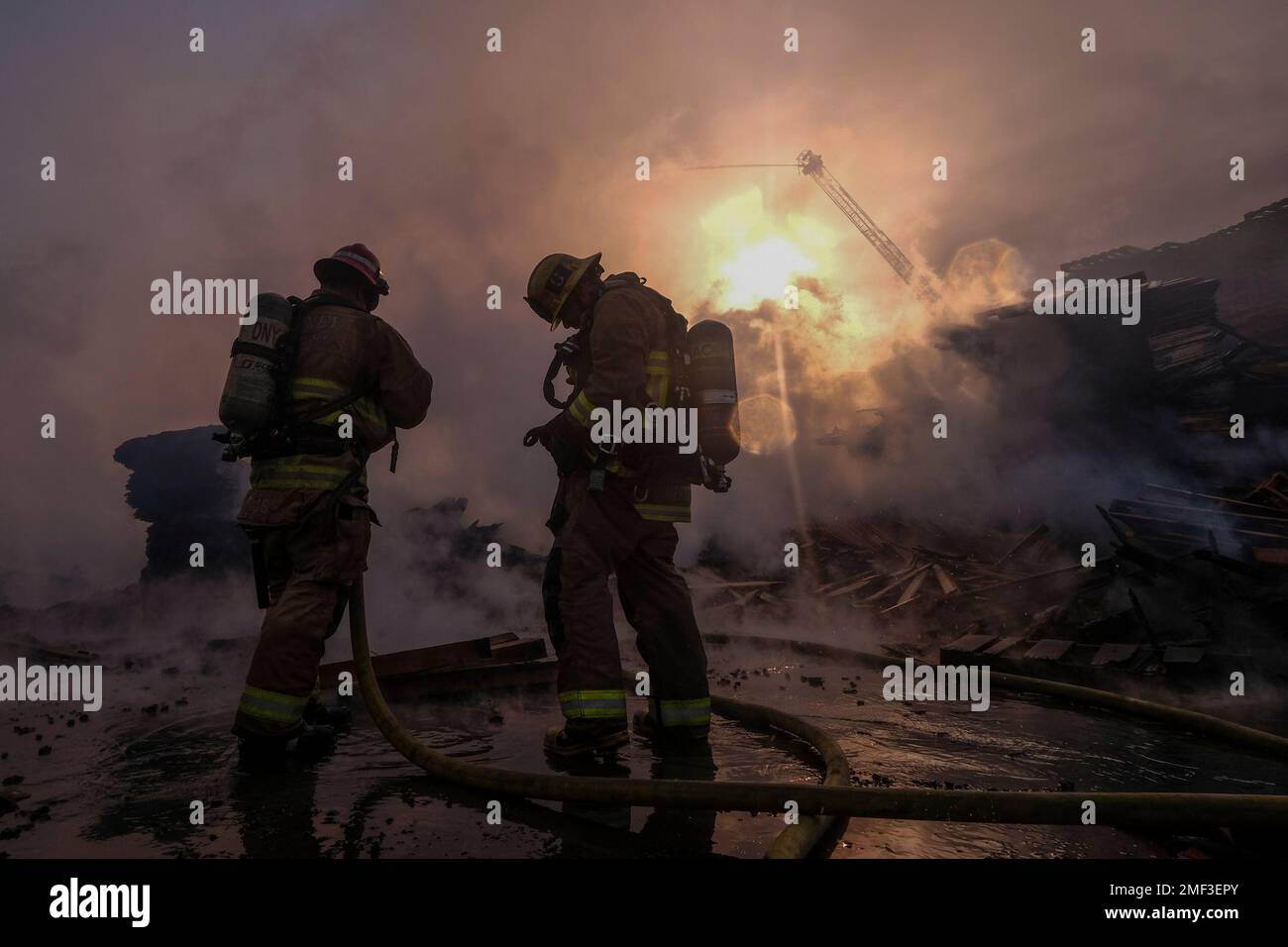 Firefighters battle a fire at a commercial yard in Compton, Calif., on ...